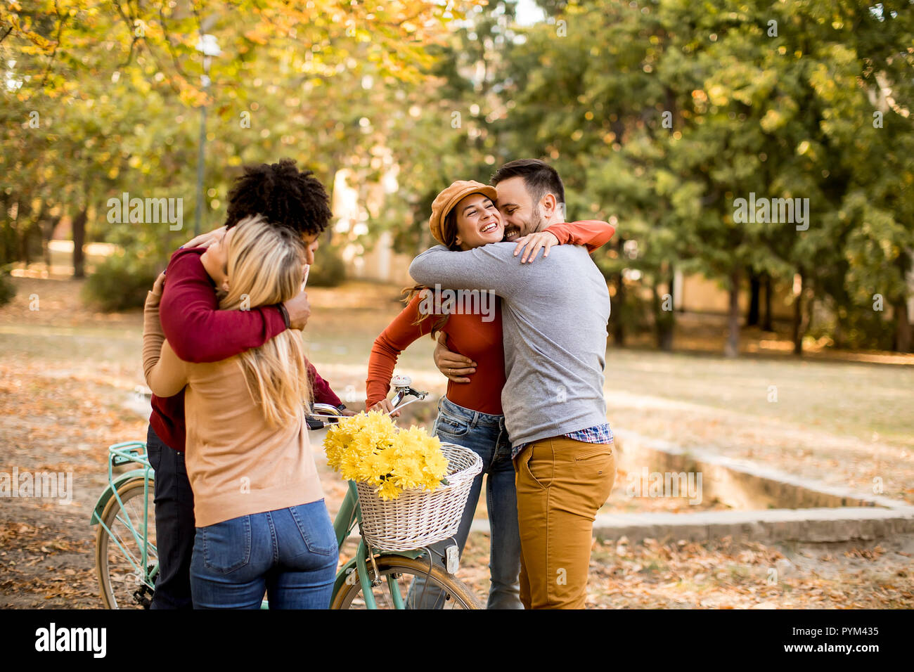 Multiracial young people walking in the autumn park and having fun ...
