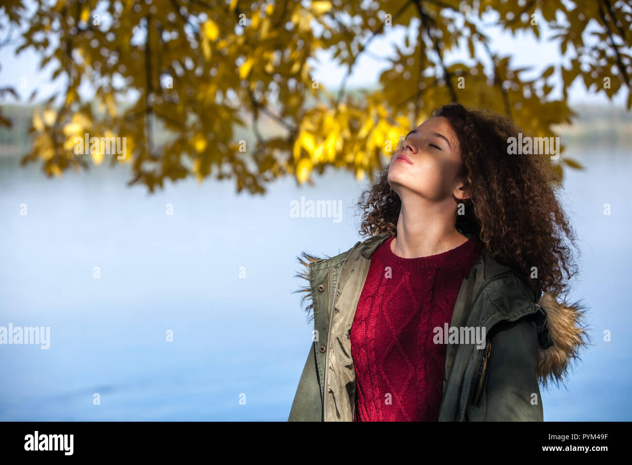 Portrait of curly hair teen girl standing by the river Stock Photo - Alamy