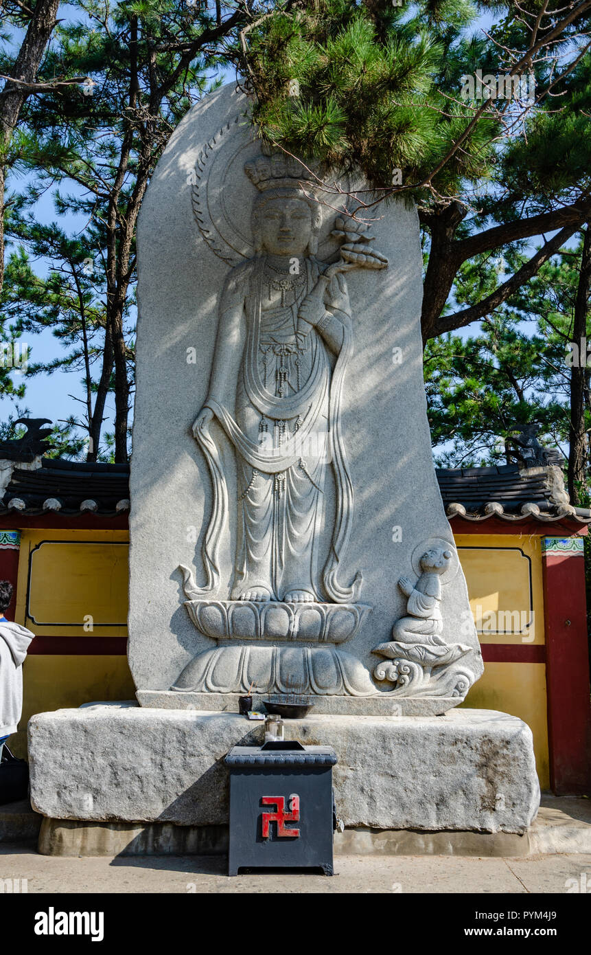 A carving of a deity in stone at Haedong Yonggung Temple in Busan ...