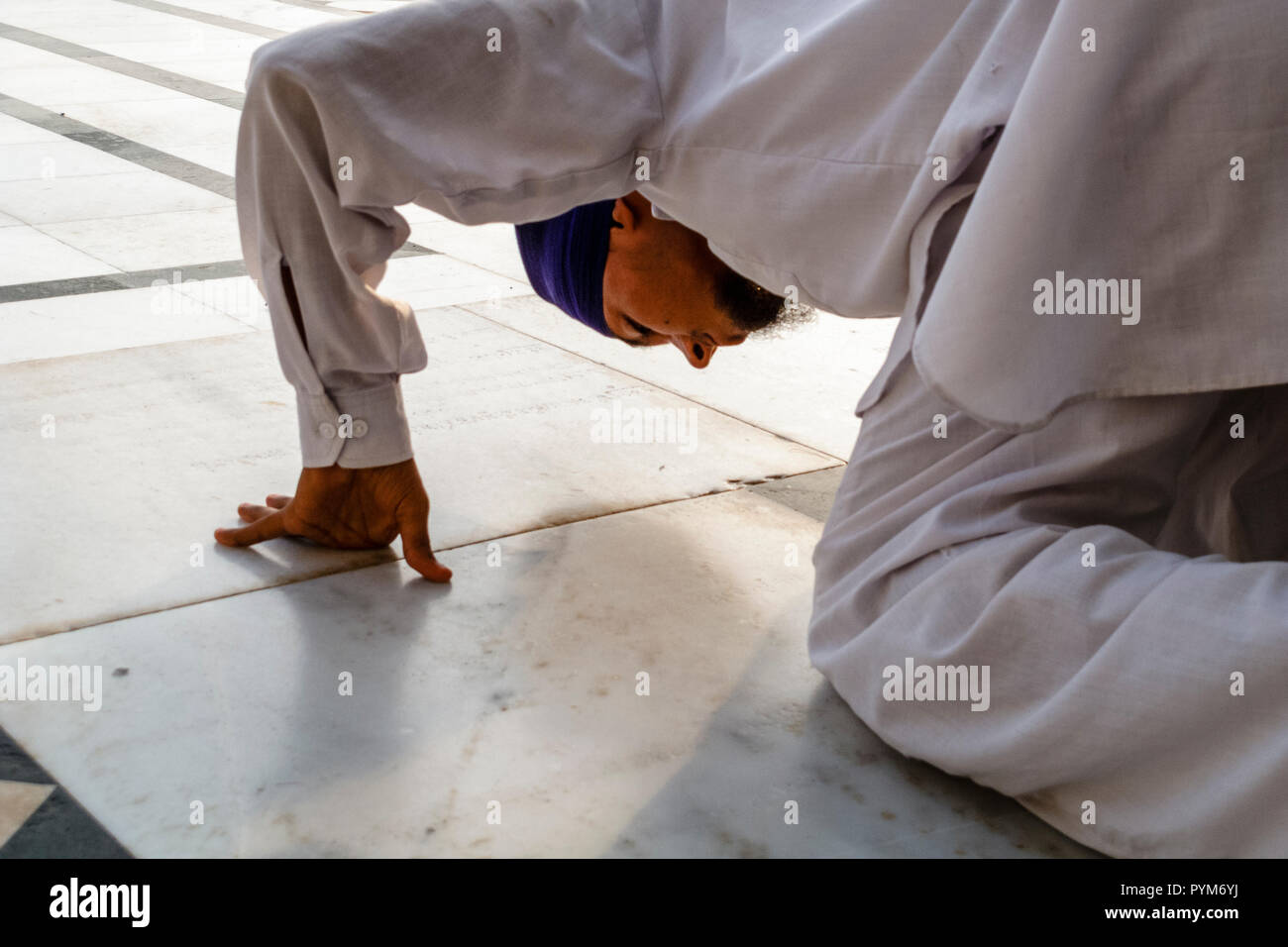 Sikh devotee praying at the entrance into the Golden Temple Complex ...