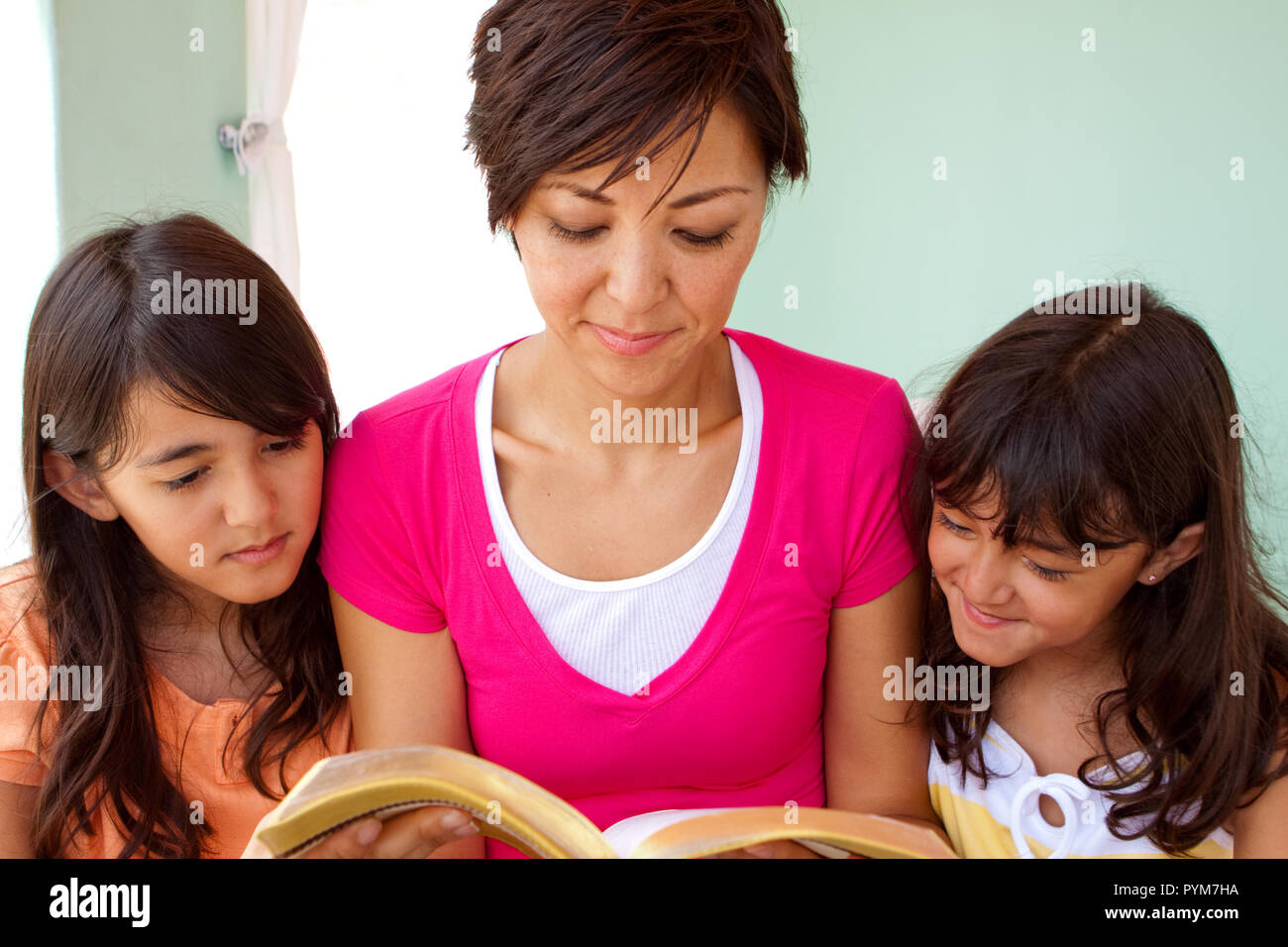Mother spending time reading with her daughters Stock Photo - Alamy