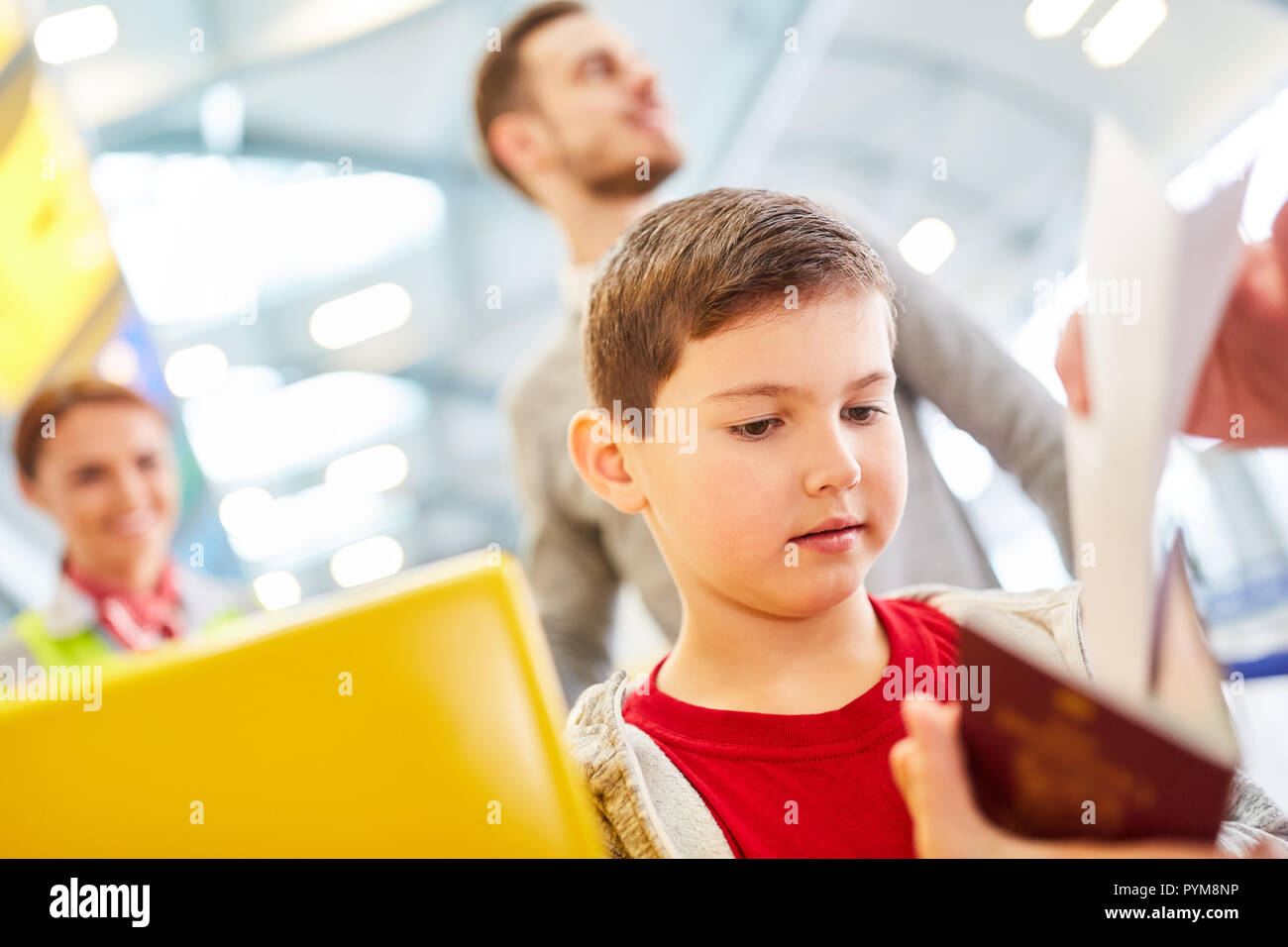 Boy looks in his passport at the airport check-in just before departure ...