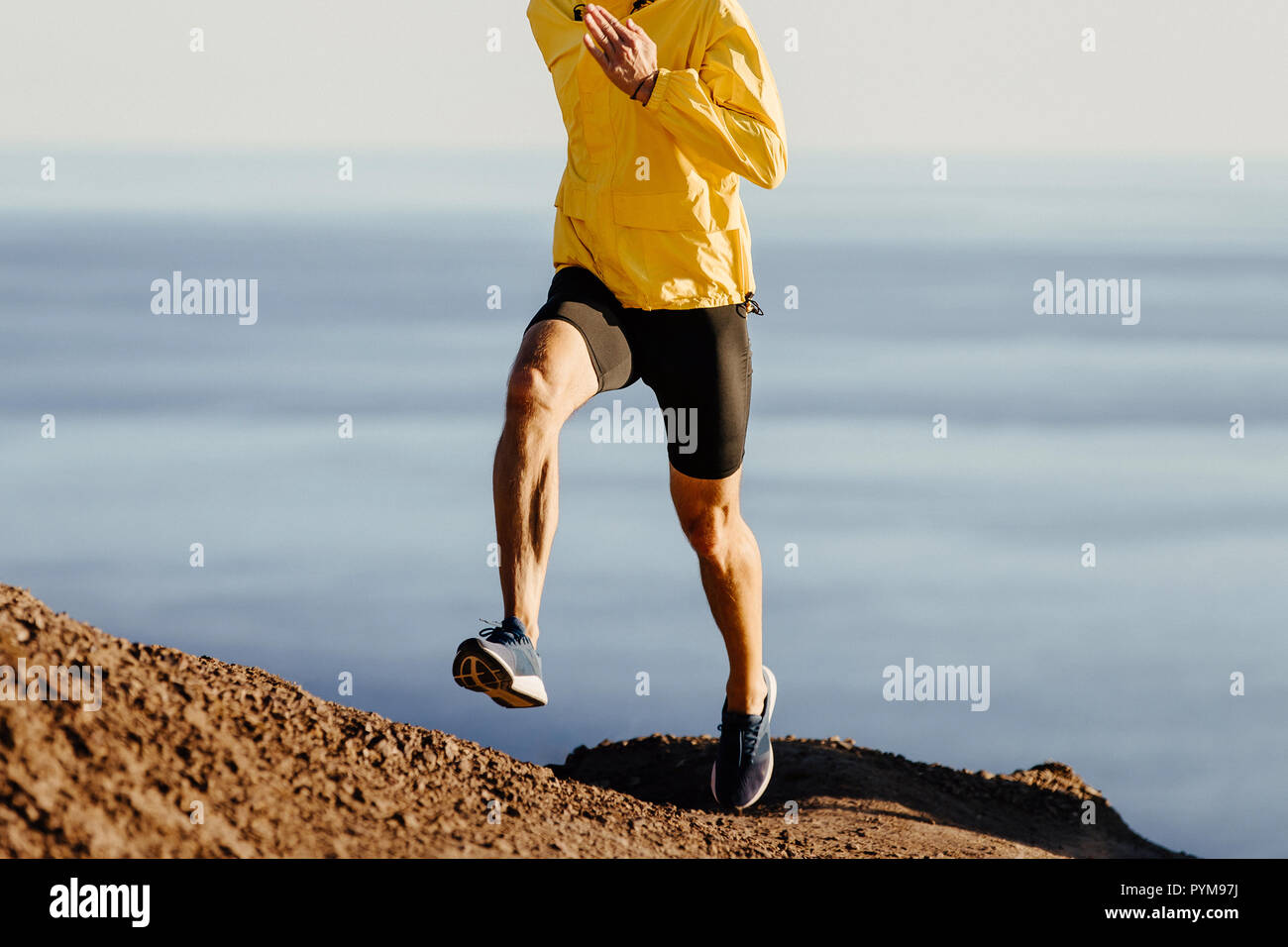 men runner running uphill in trail on background of sea Stock Photo - Alamy