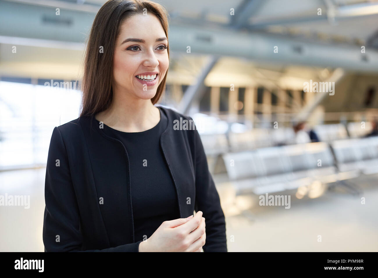Young businesswoman on business trip is happy about a message in the ...