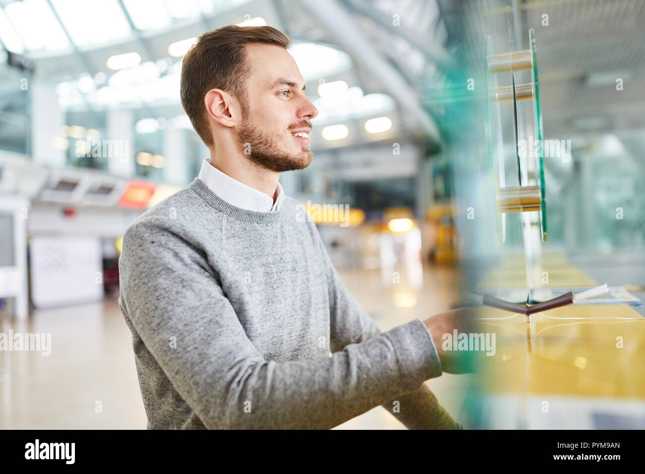 Man as a passenger at the check in desk in the airport terminal at the ...