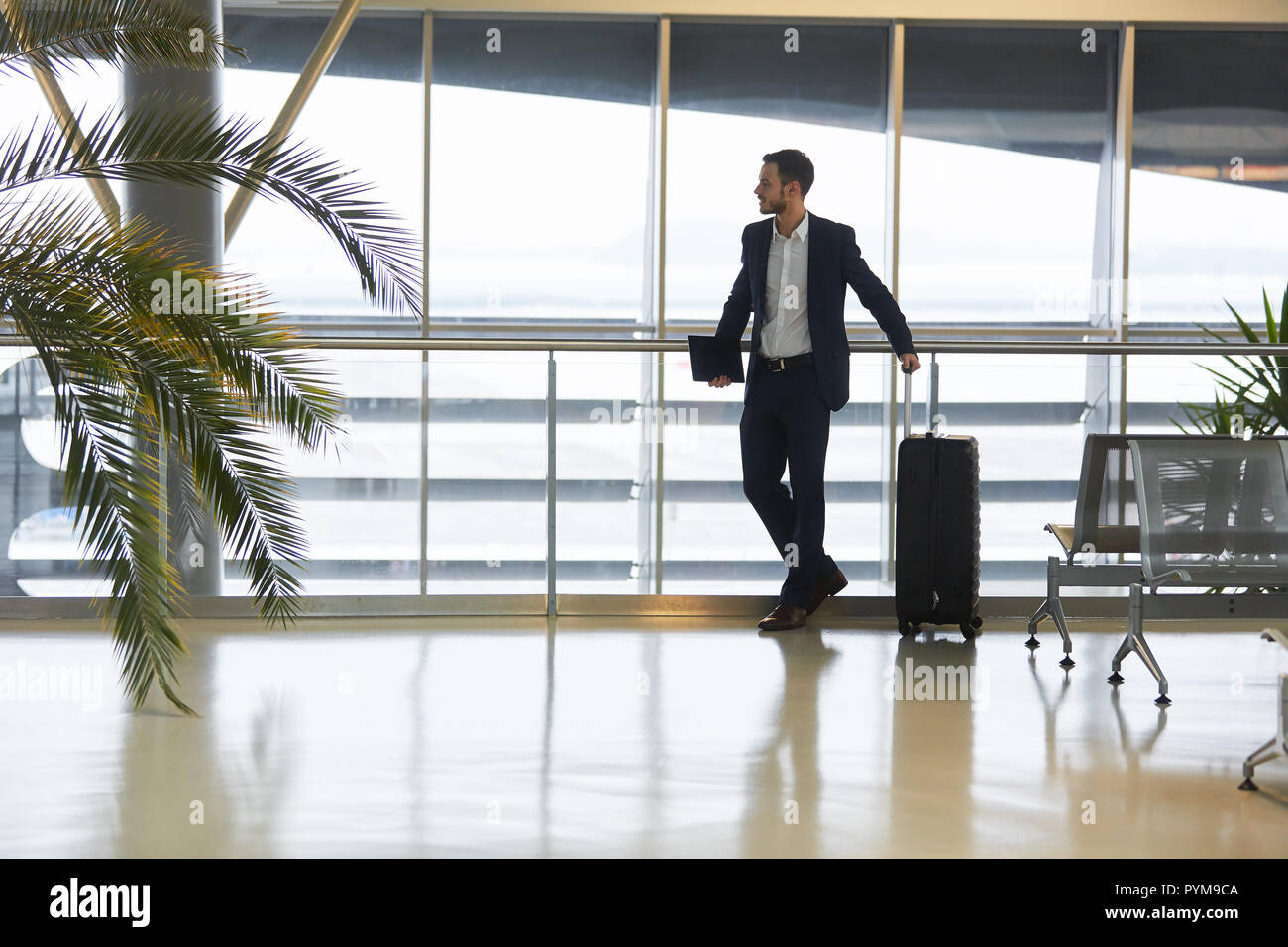 Businessman on mission waits for his connecting flight in airport ...