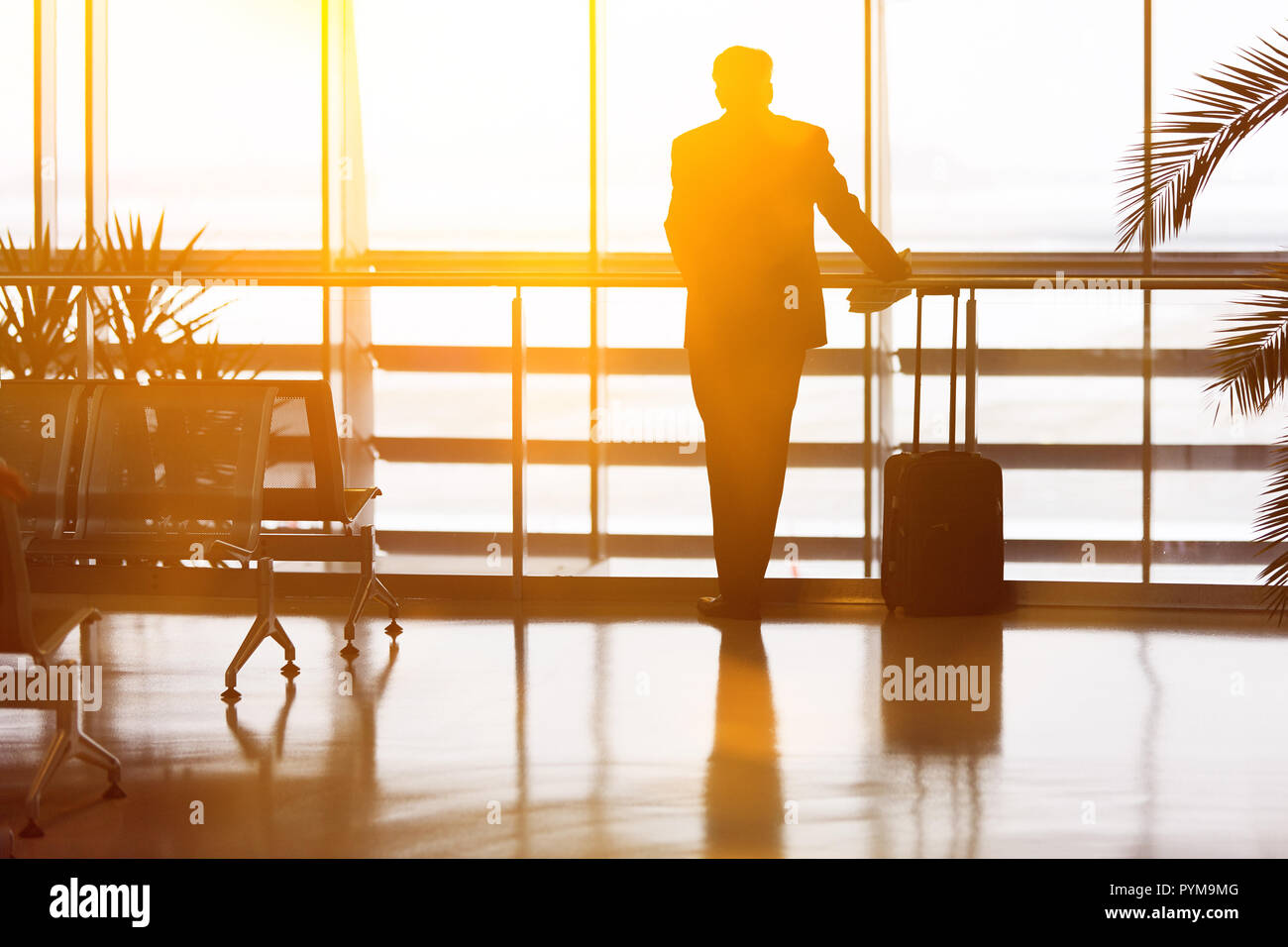 Businessman looks out of the window onto the runway before leaving the ...