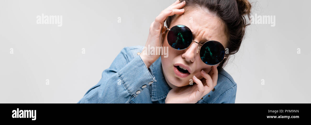 Young Brunette Girl In Round Glasses Hairs Are Gathered In A Bun The