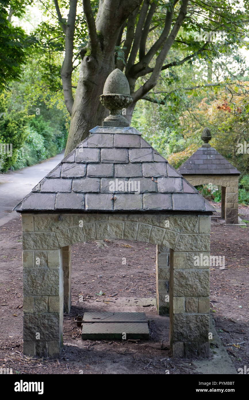 Stone structures mark a path in a park. They may be decorative or serve ...