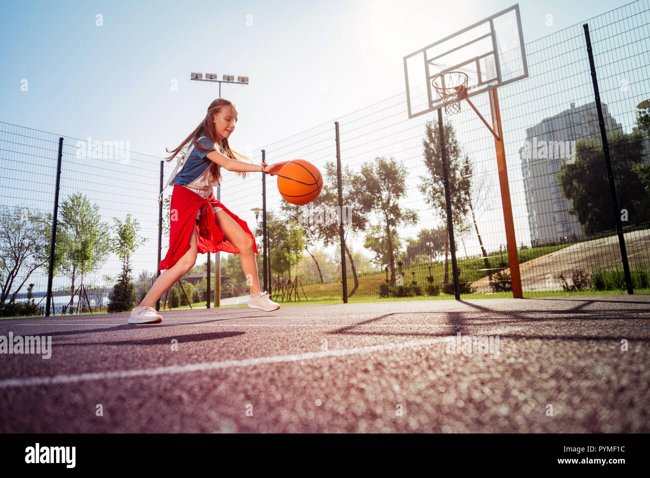 Cheerful longhaired girl running on stadium with pleasure Stock Photo ...