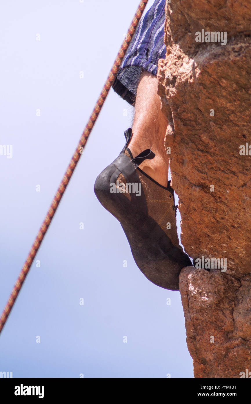 Detail of rock climbers feet with climbing shoes on while climbing ...