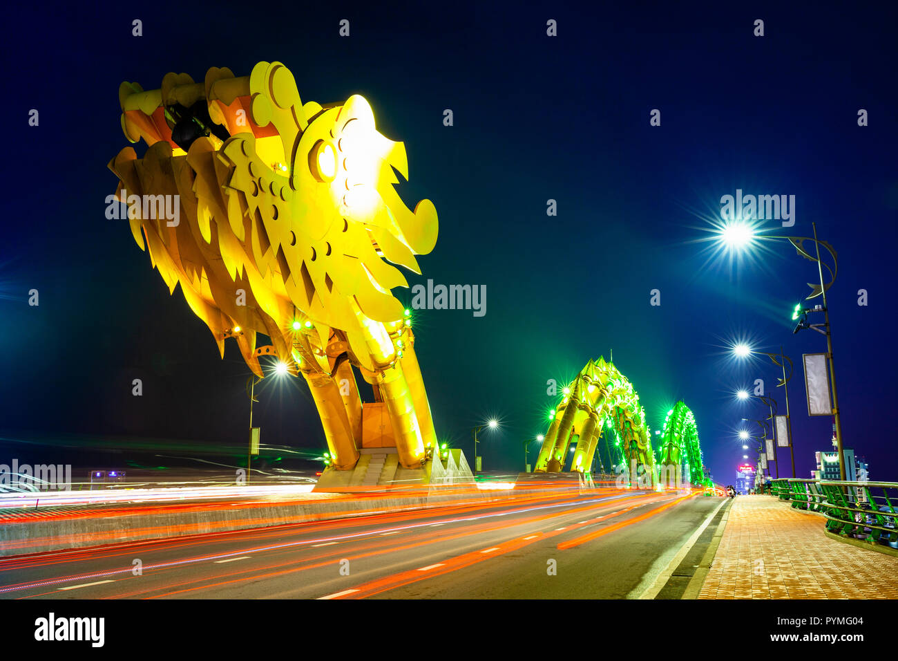 The Dragon Bridge (Cau Rong) with yellow-colored illumination at night ...
