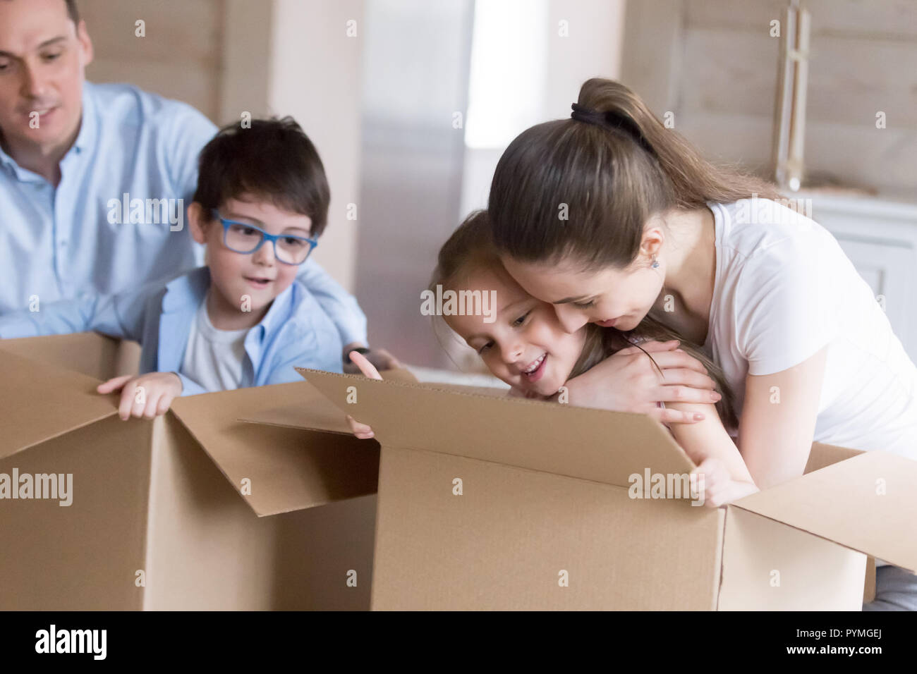 Family playing have fun with boxes at new home Stock Photo - Alamy
