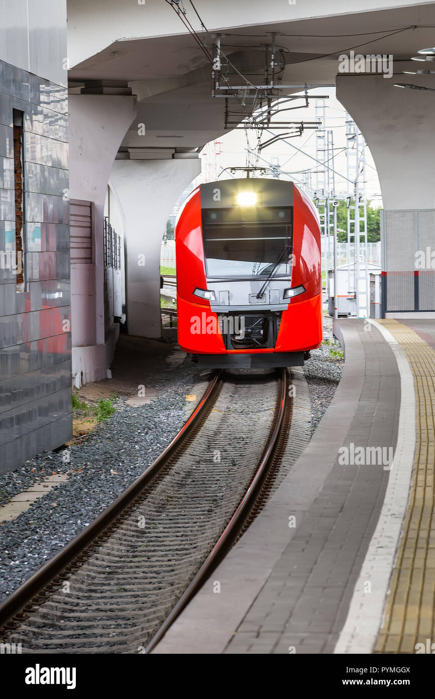 Modern red train approaching the train station Stock Photo - Alamy