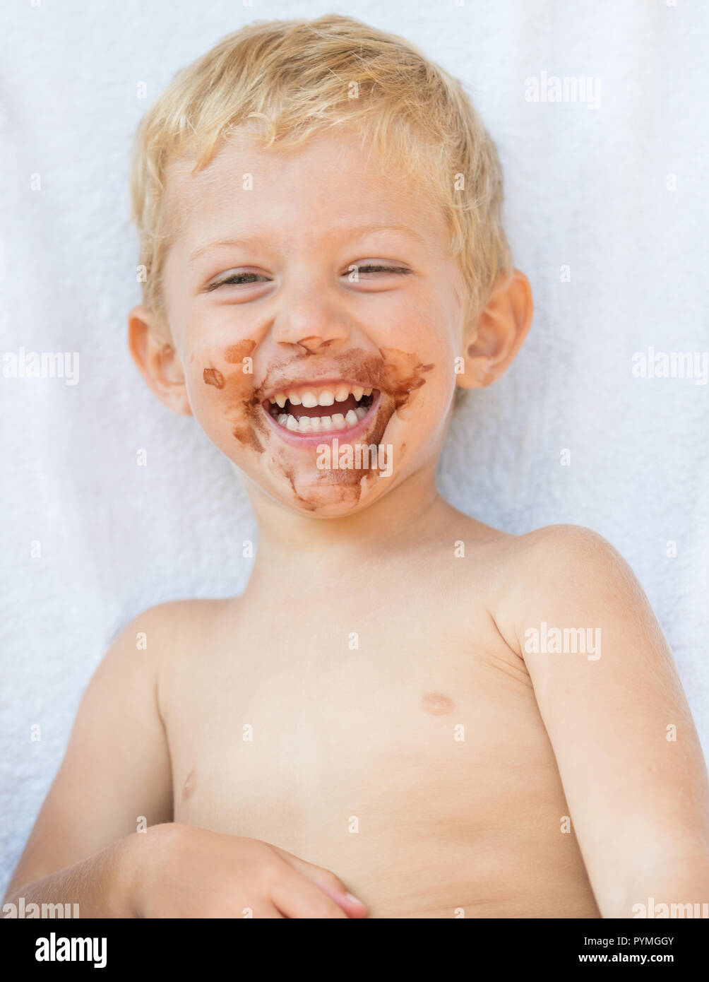 Portrait of fair-haired boy with chocolate on his face isolated on ...