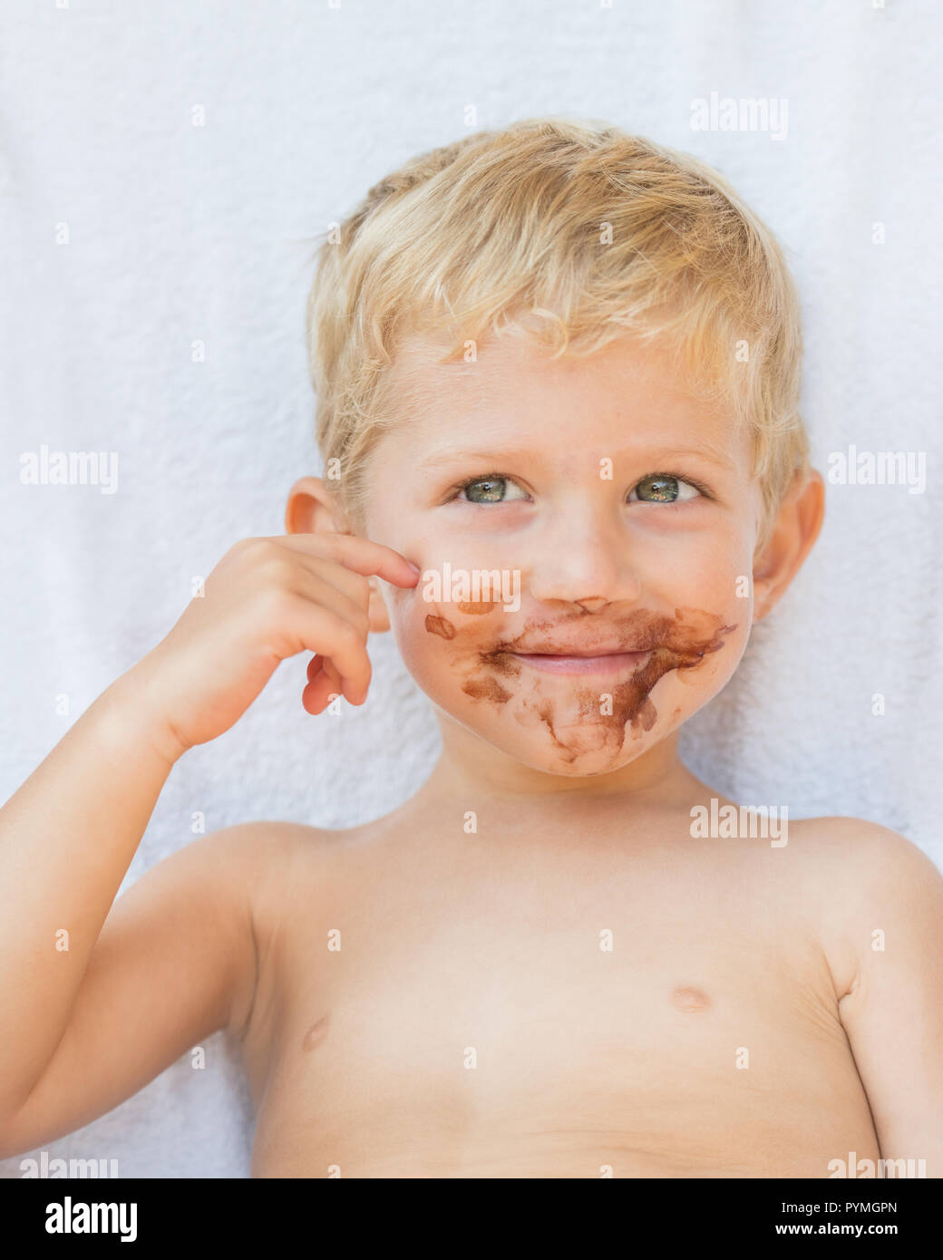 Portrait of fair-haired boy with chocolate on his face isolated on ...