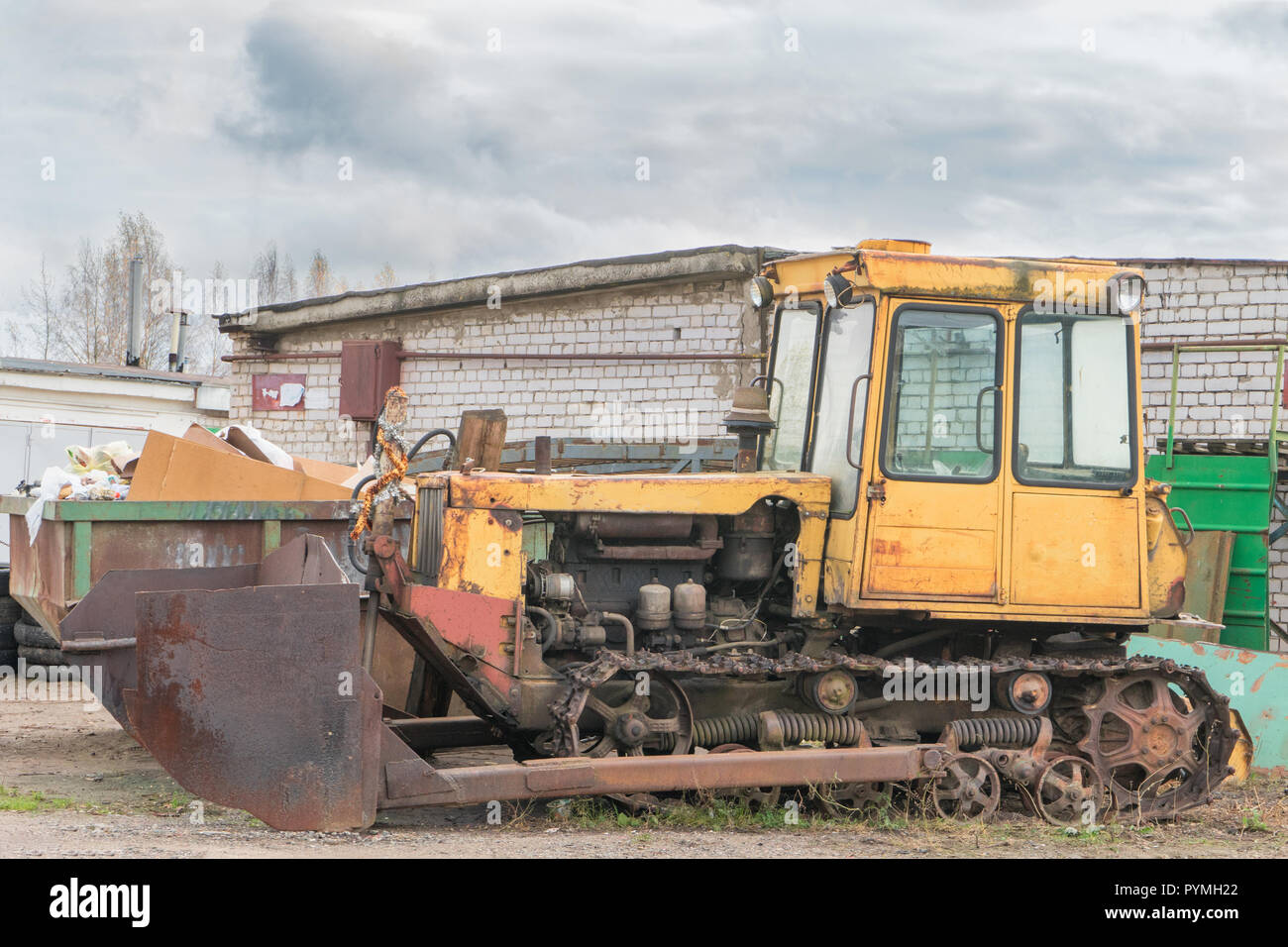 old rusty yellow abandoned tractor with bucket Stock Photo - Alamy