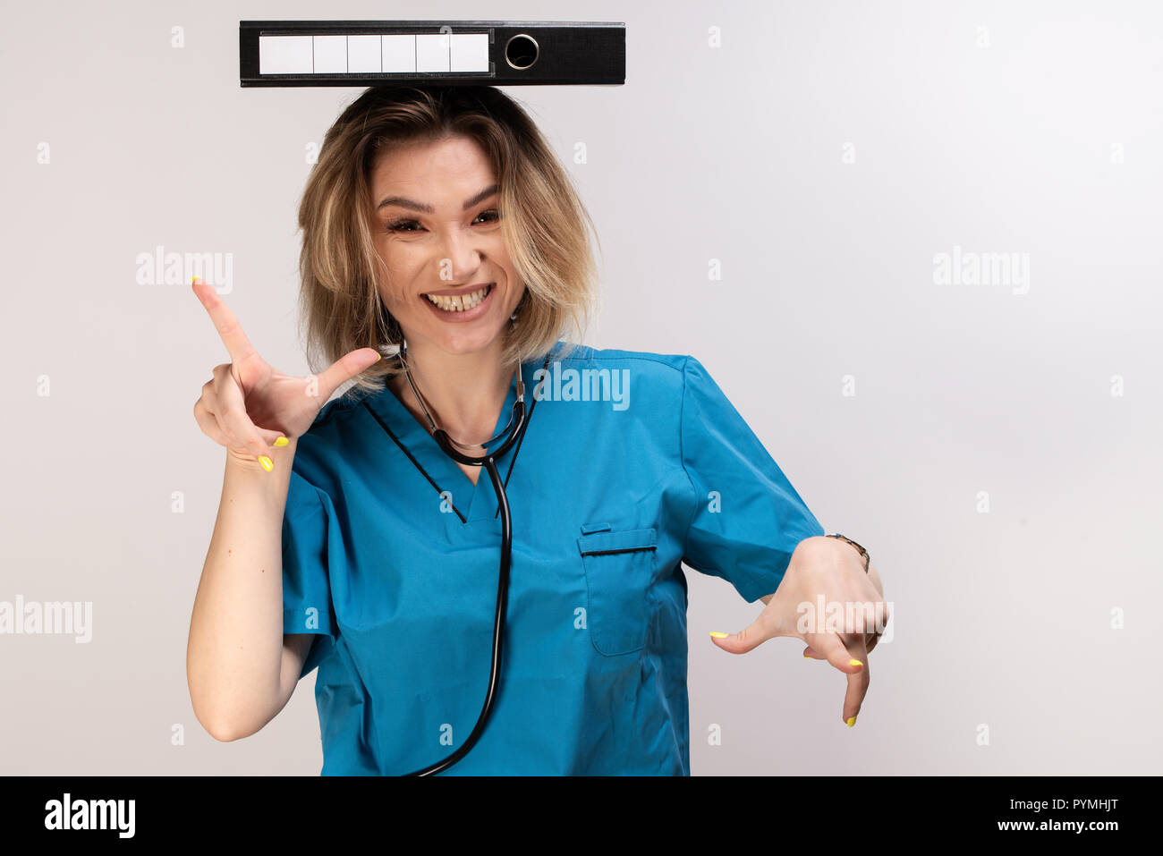 Crazy female doctor balancing documents on her head smiling very big to ...