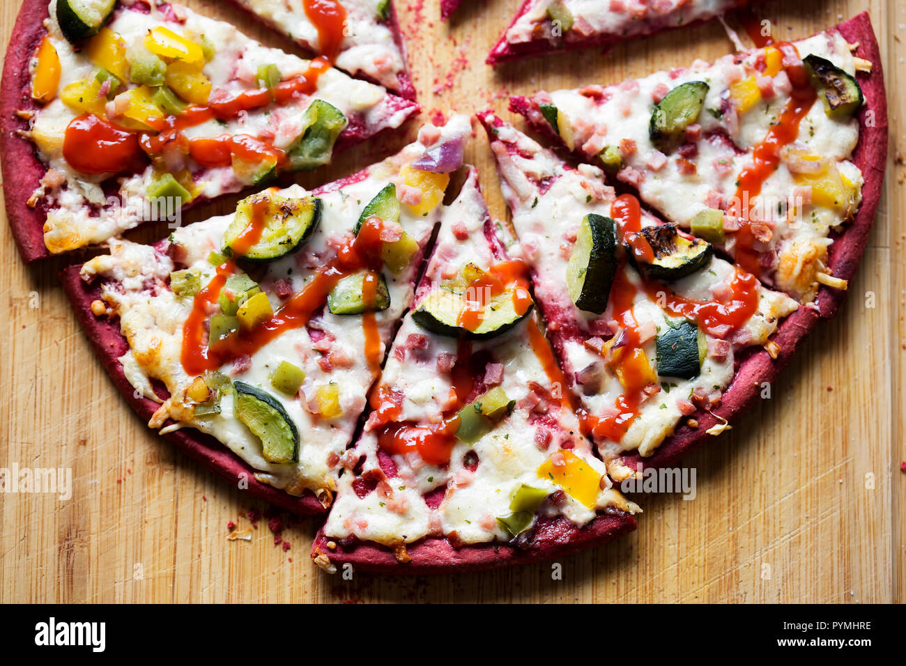 Beetroot base pizza with zucchini, smoked ham, cheese & red onion Stock ...