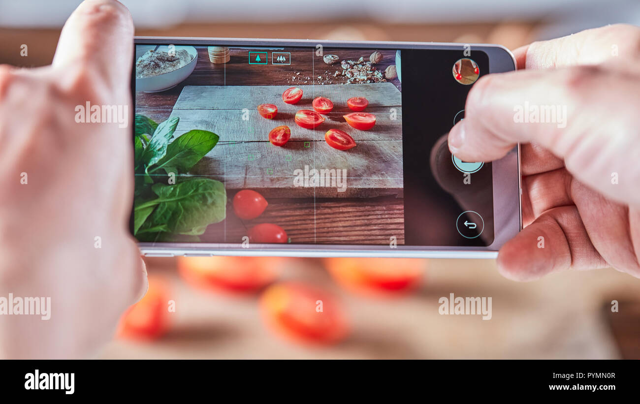 Woman's hands are shooting on a smartphone photo of sliced tomatoes on ...