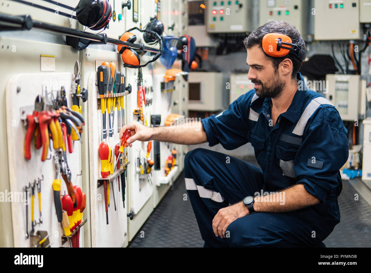 Marine engineer officer working in engine room Stock Photo - Alamy