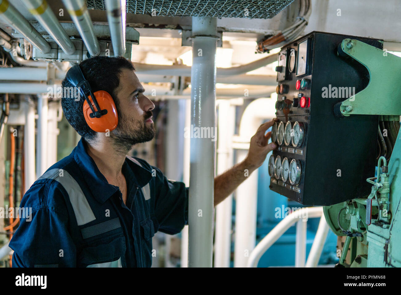 Marine engineer officer working in engine room Stock Photo - Alamy