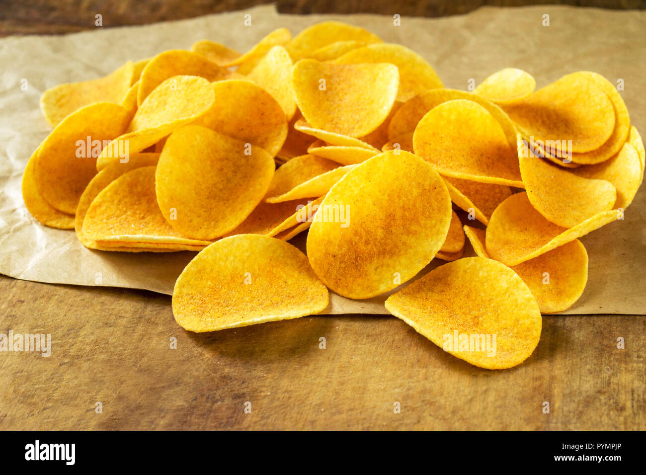 Potato flat chips on wrapping paper, close-up. Fast food Stock Photo ...