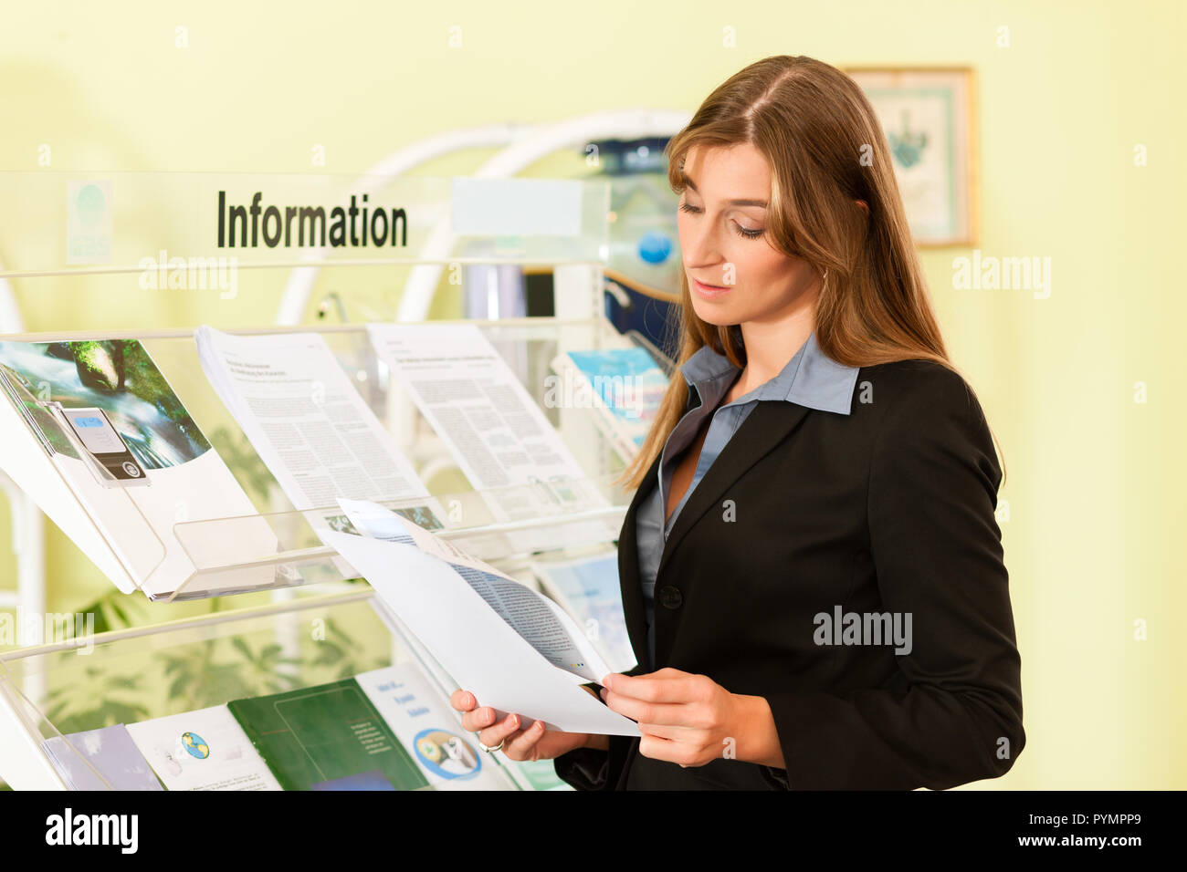 Young businesswoman reading leaflet Stock Photo - Alamy
