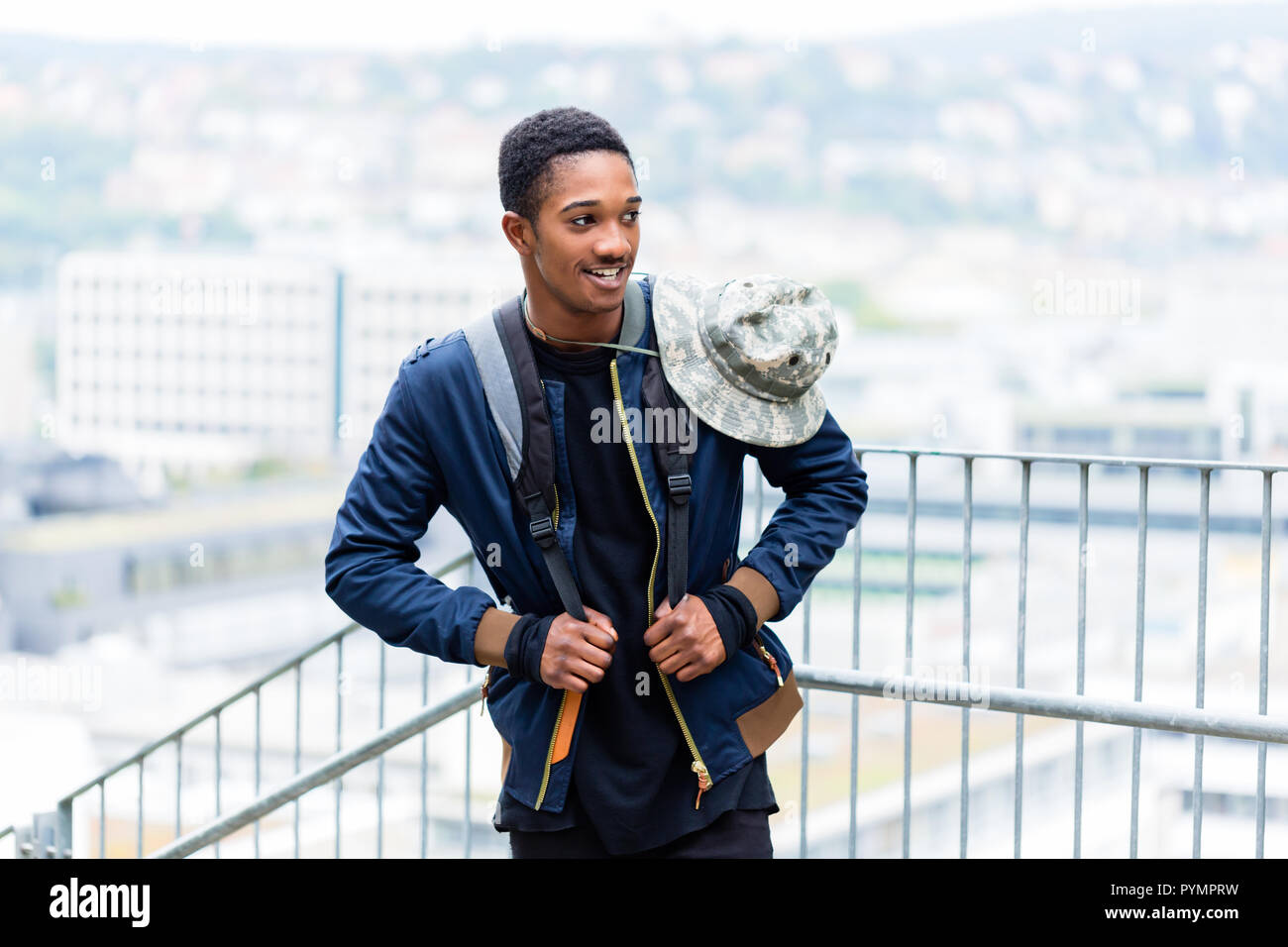 Smiling young traveler with hat and backpack Stock Photo - Alamy