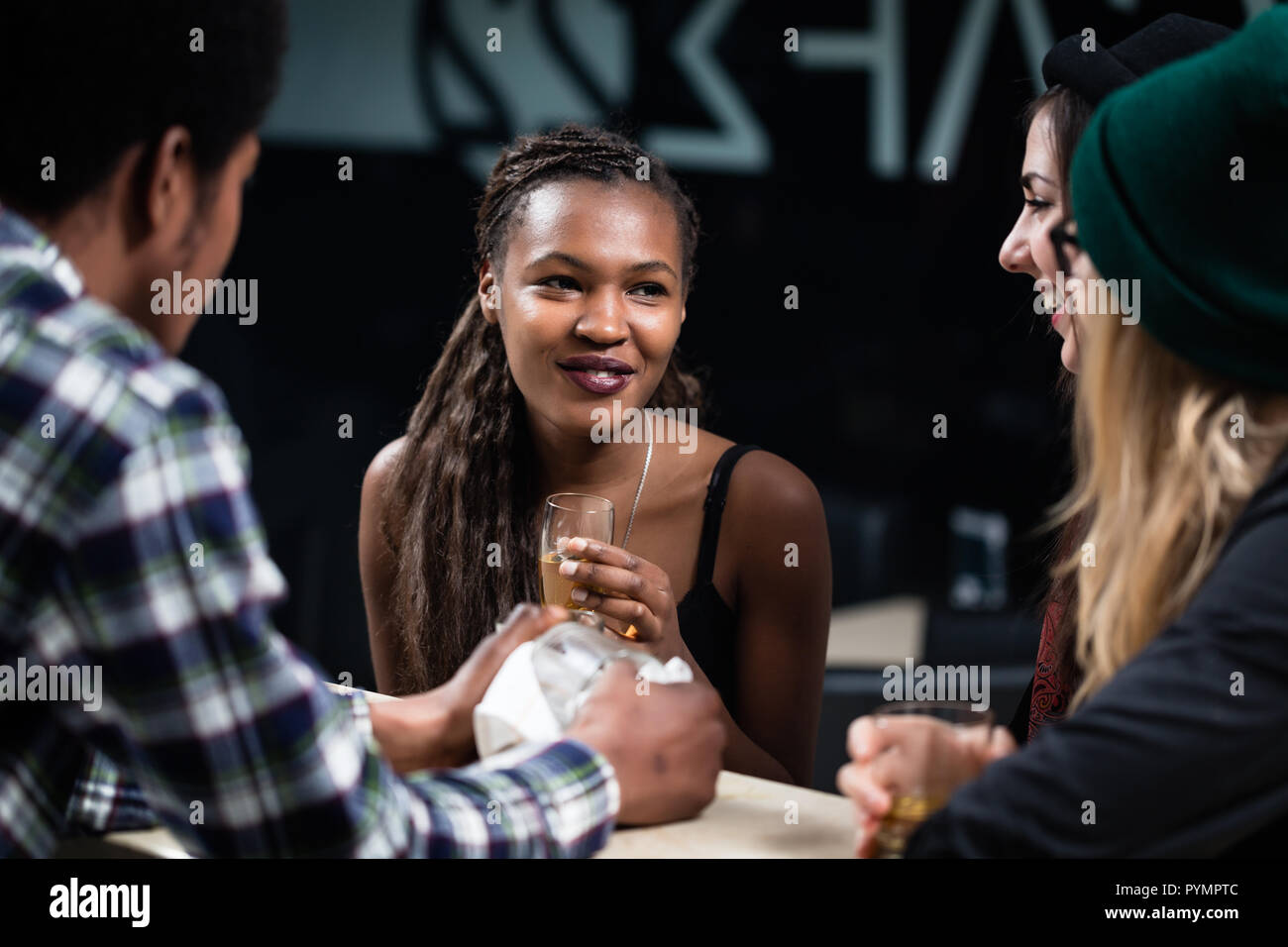 Smiling girl enjoying drinks with her friends Stock Photo - Alamy