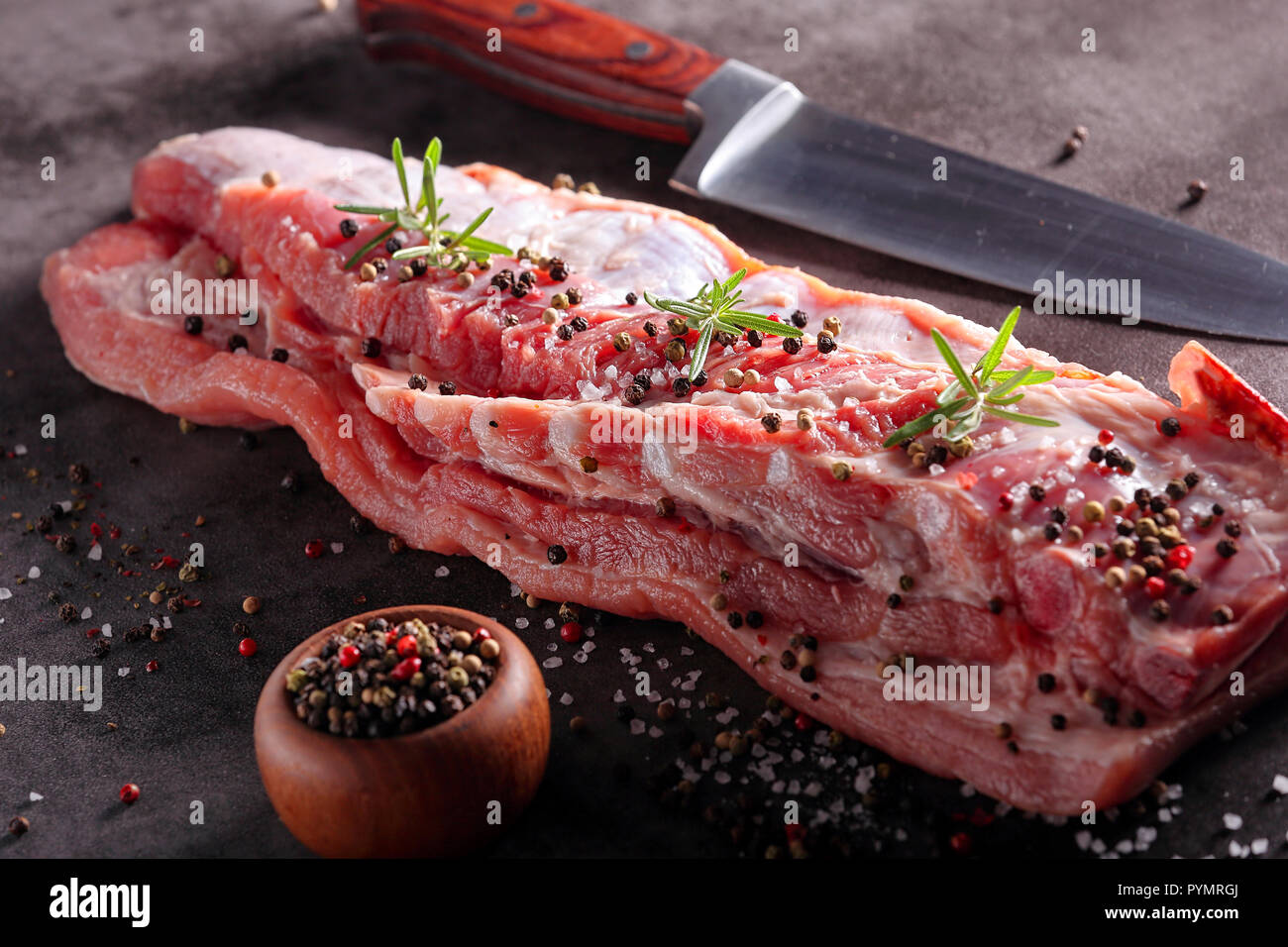 Raw ribs with spices on a stone background with empty space for text ...