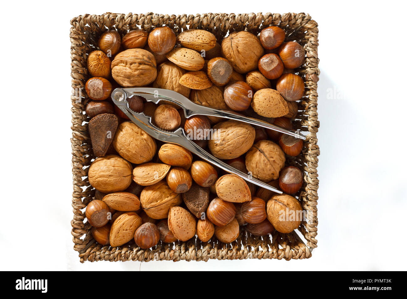 Mixed nuts in a woven basket with nut cracker Stock Photo - Alamy