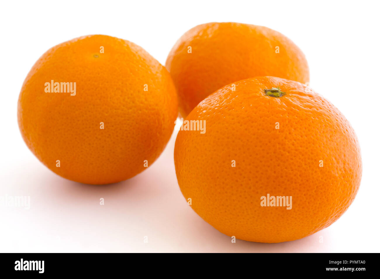 Three mandarins on white surface Stock Photo - Alamy