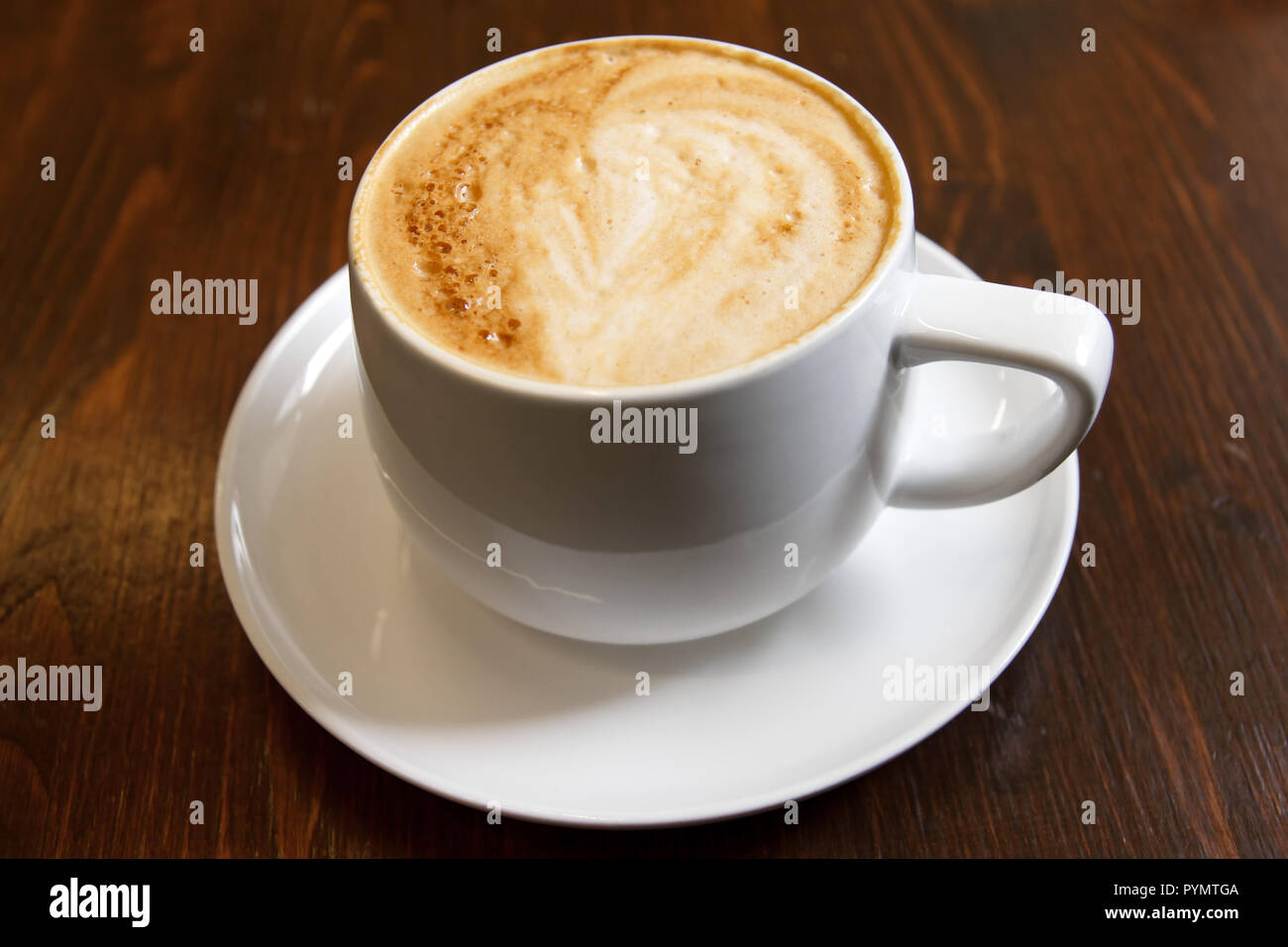 Classic foamy cappuccino in on a dark grained wood table. Detail. From ...