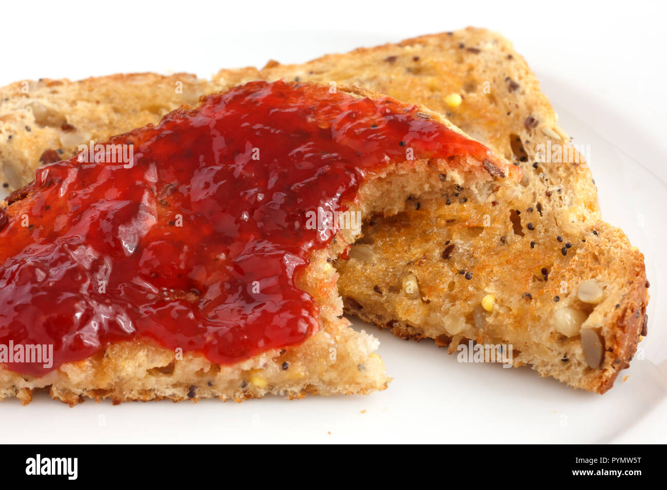 Slice of multi-seed wholegrain bread toasted and buttered with jam ...