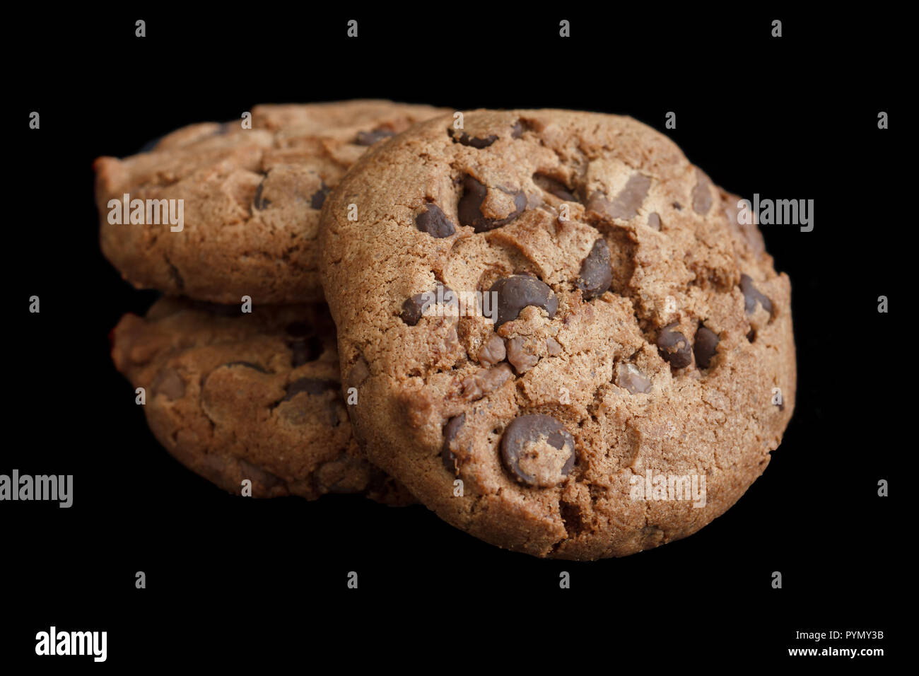 Three chocolate chip cookies isolated on black Stock Photo - Alamy