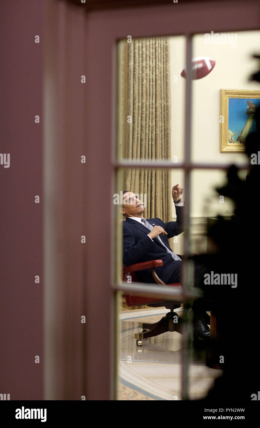 President Barack Obama plays with a football in the Oval Office 4/23/09 ...