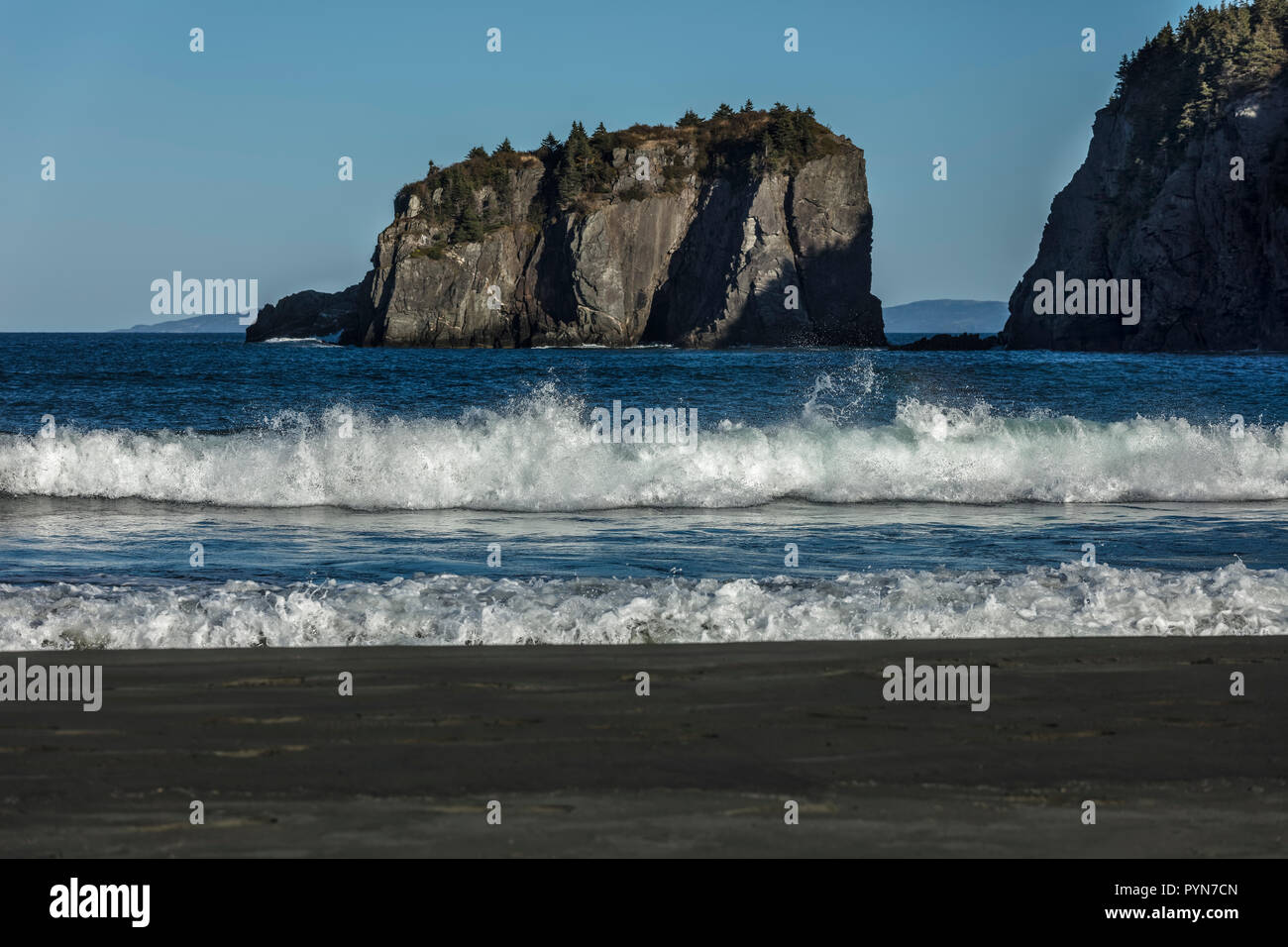 Surf and waves on sandy beach with rock Stock Photo - Alamy