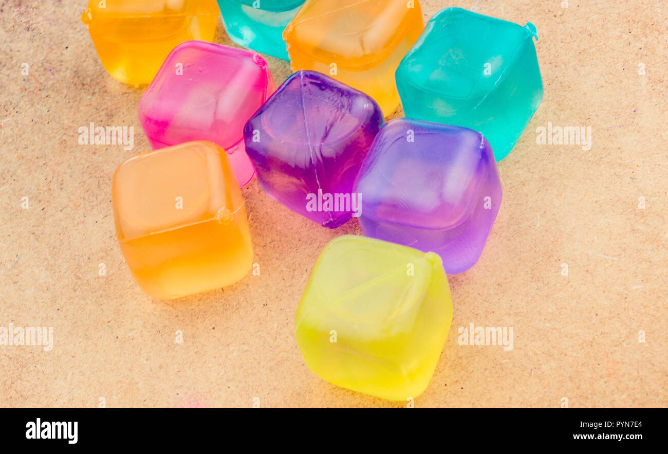 Fake colorful ice cubes on a brown background Stock Photo - Alamy