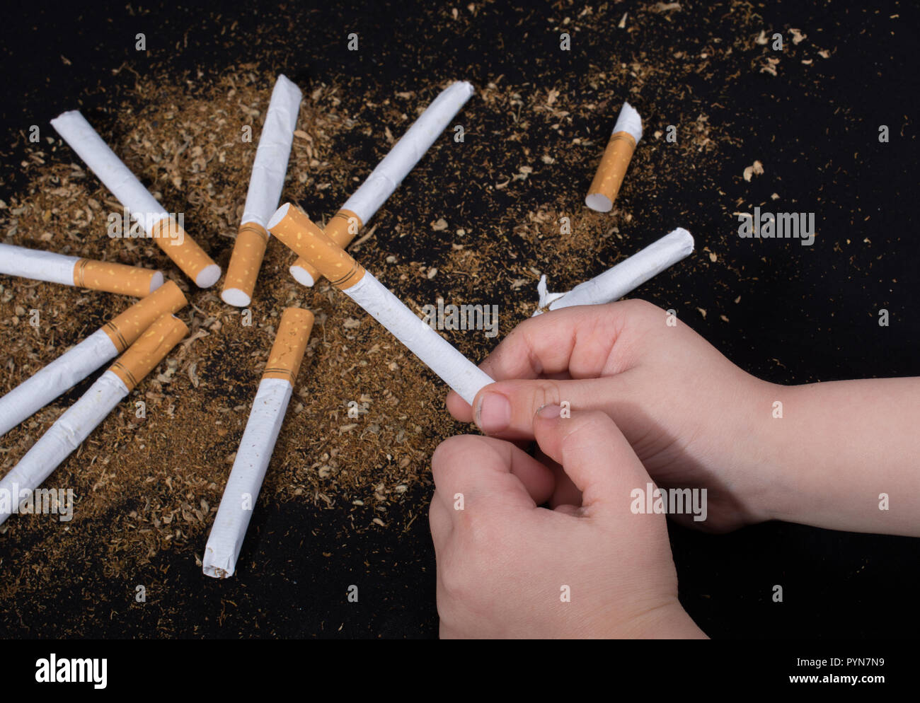 Hand is holding a cigarette on black background Stock Photo - Alamy