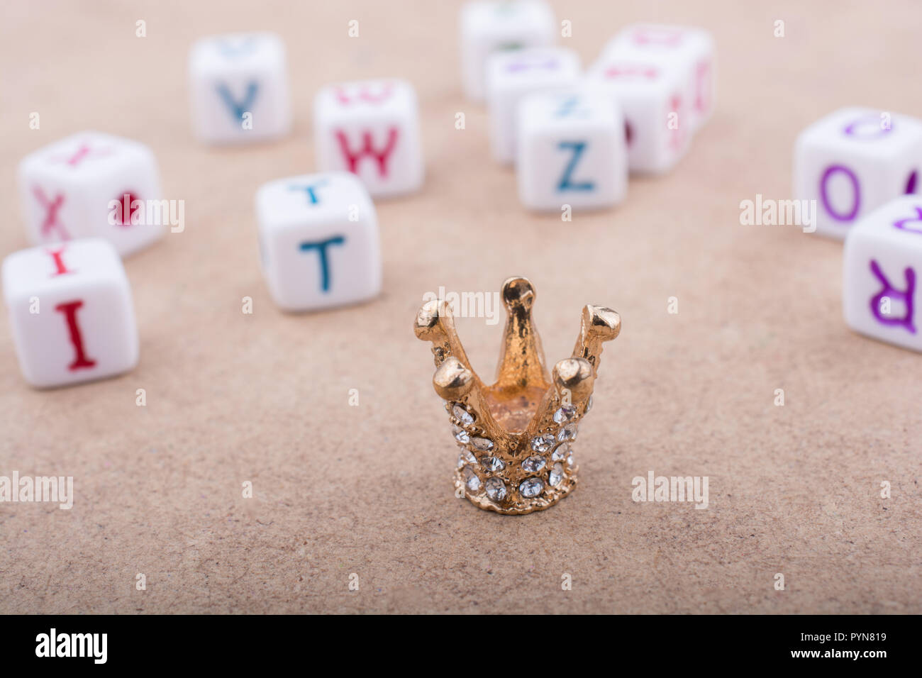 Golden color crown model in front of the letter cubes Stock Photo - Alamy
