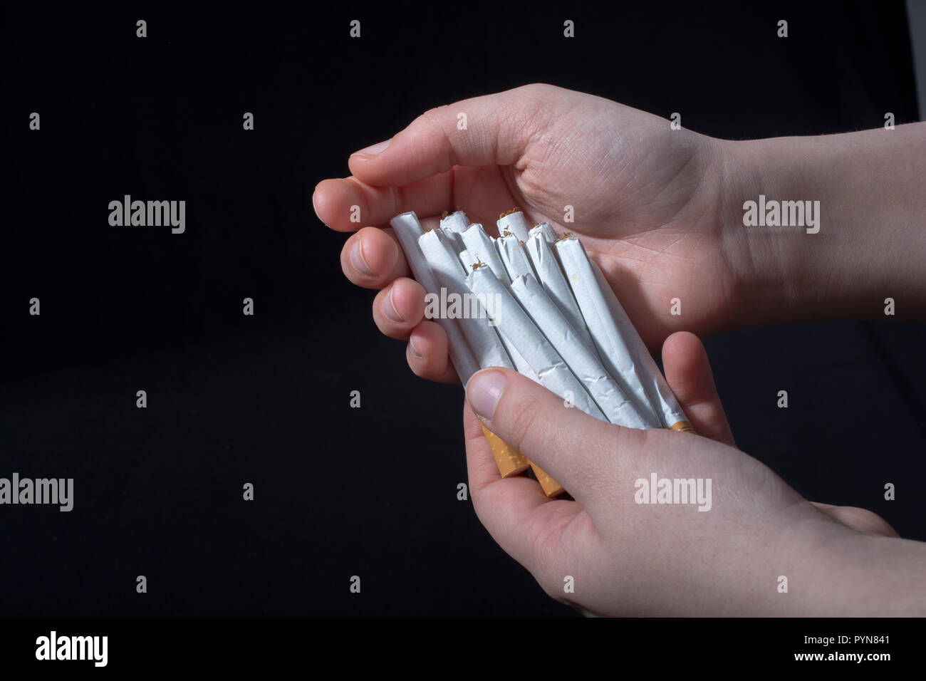 Hand is giving out bundle of cigarettes on black background Stock Photo ...