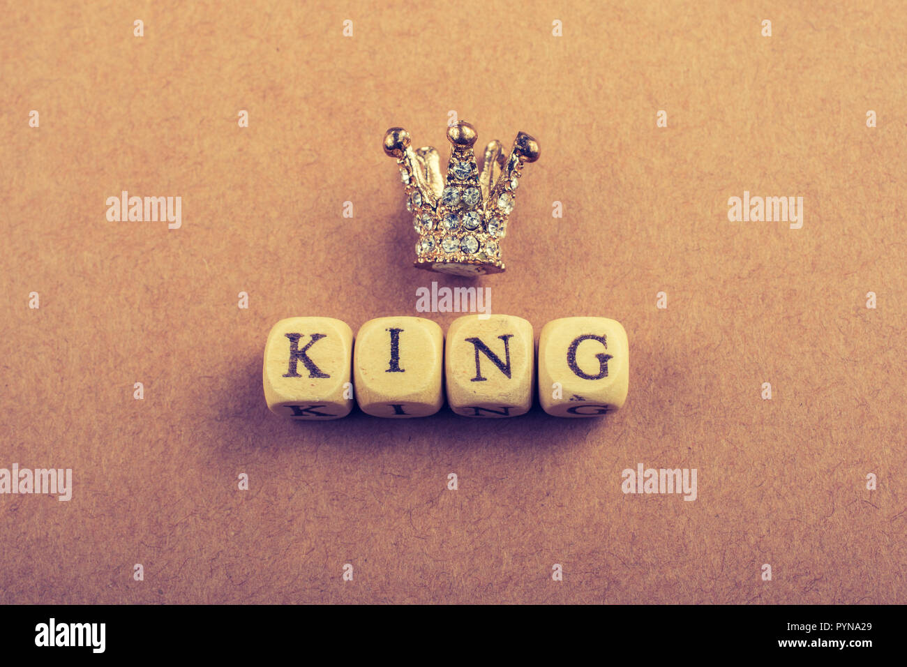 Tiny model crown beside the king wording on brown Stock Photo - Alamy