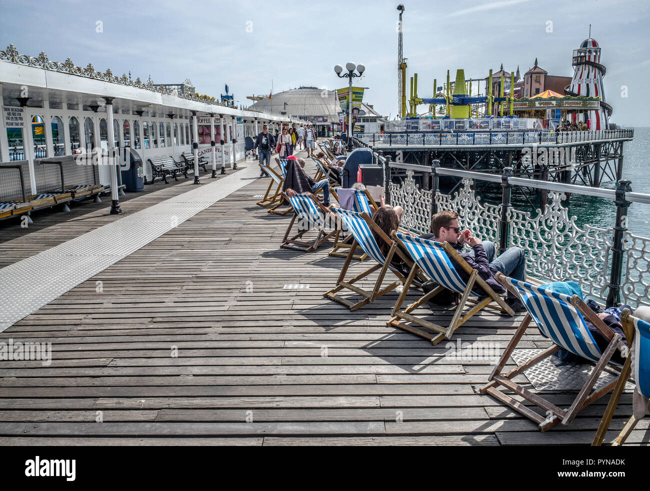 seated people on Brighton pier Stock Photo - Alamy