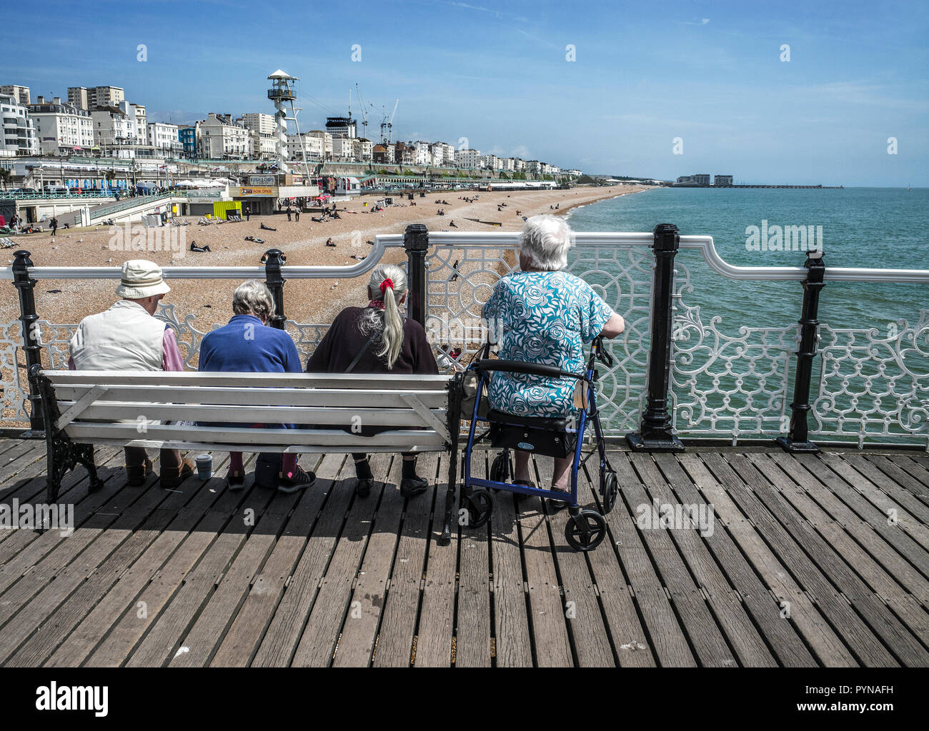 seated people on Brighton pier Stock Photo - Alamy