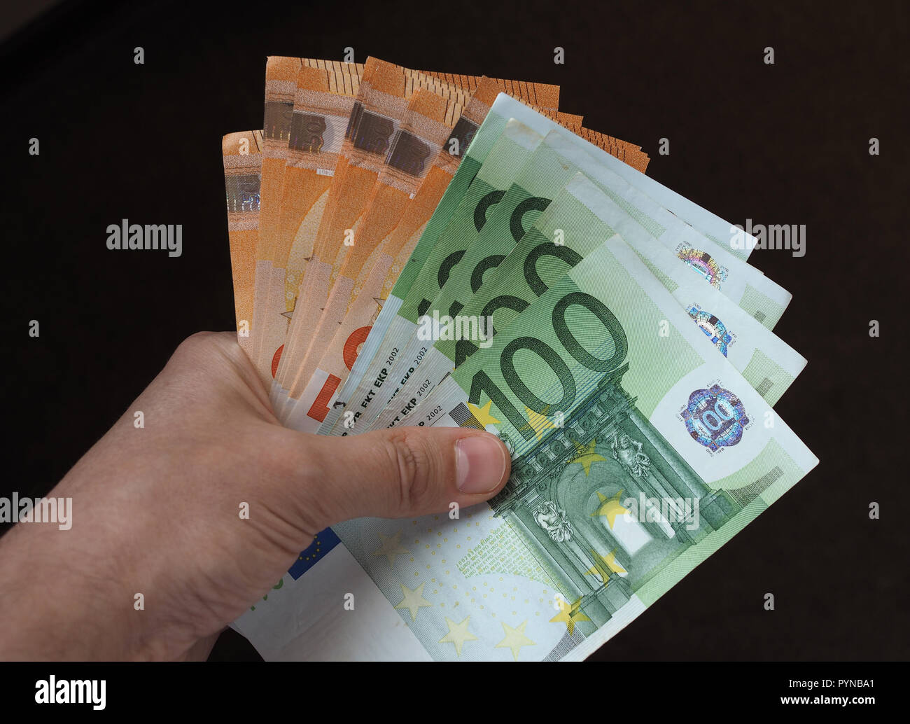 Hand holding and giving Euro banknotes money (EUR), currency of ...