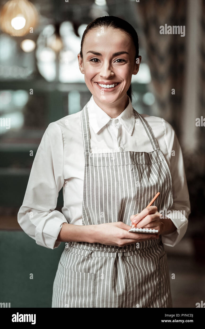 Pretty young waitress looking straight at camera Stock Photo - Alamy