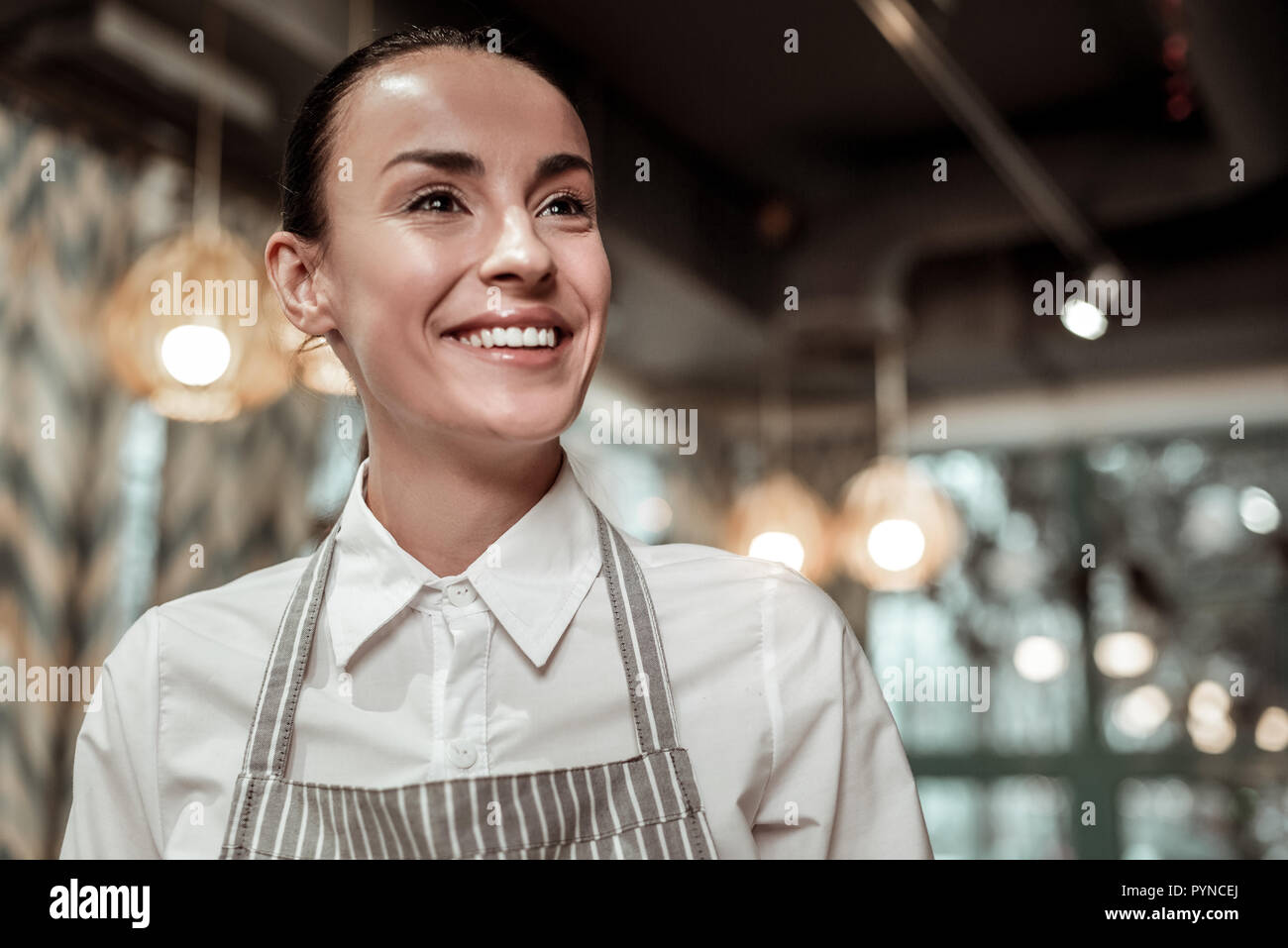 Dreamy waitress expressing positivity during her workday Stock Photo ...