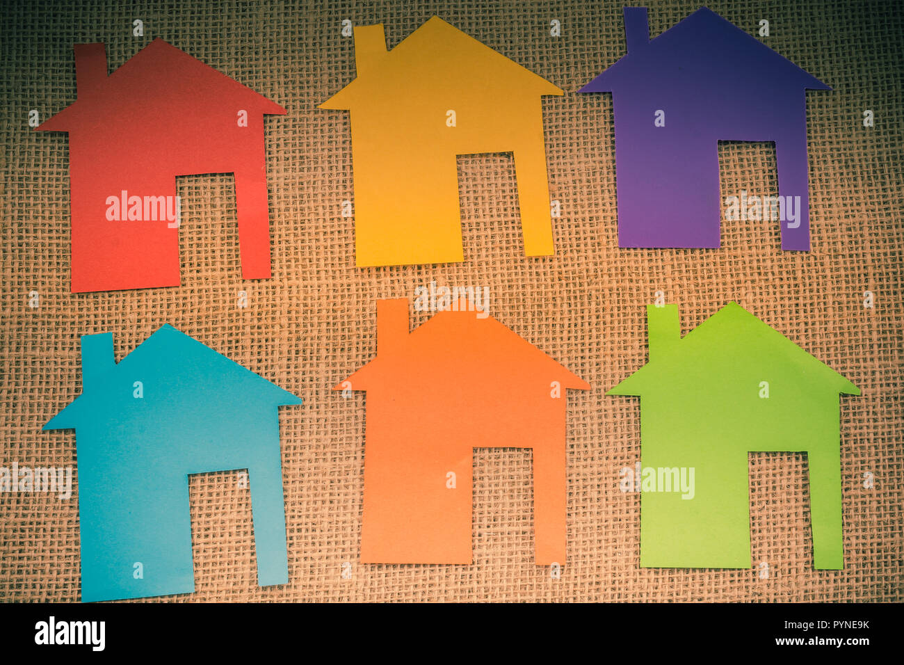 Little house shape cut out of colorful paper on a canvas background ...