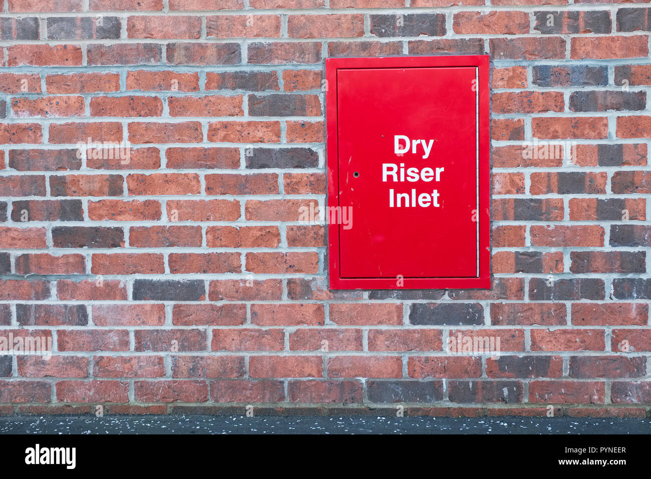 Dry riser inlet box red on brick wall for emergency fire services water ...